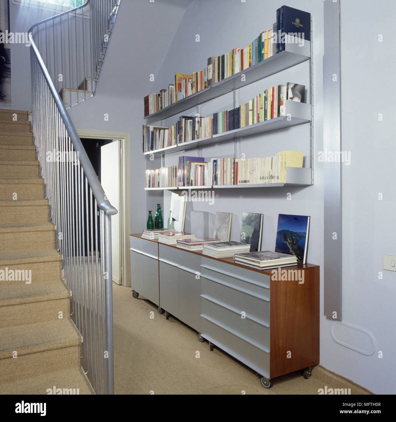Hallway with staircase with metal banister and storage cabinets Stock ...