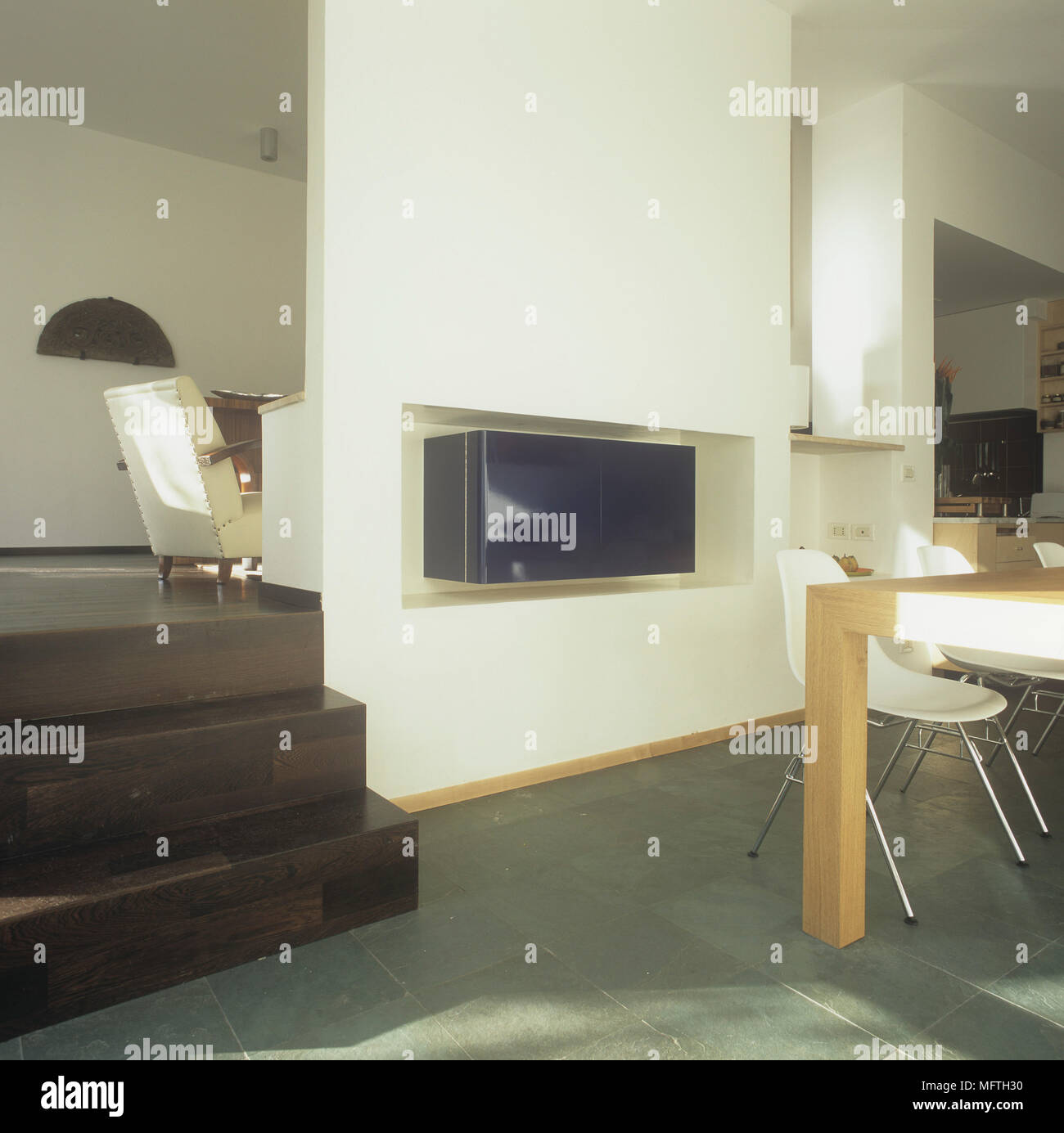 Dining area with steps leading up to sitting area Stock Photo - Alamy