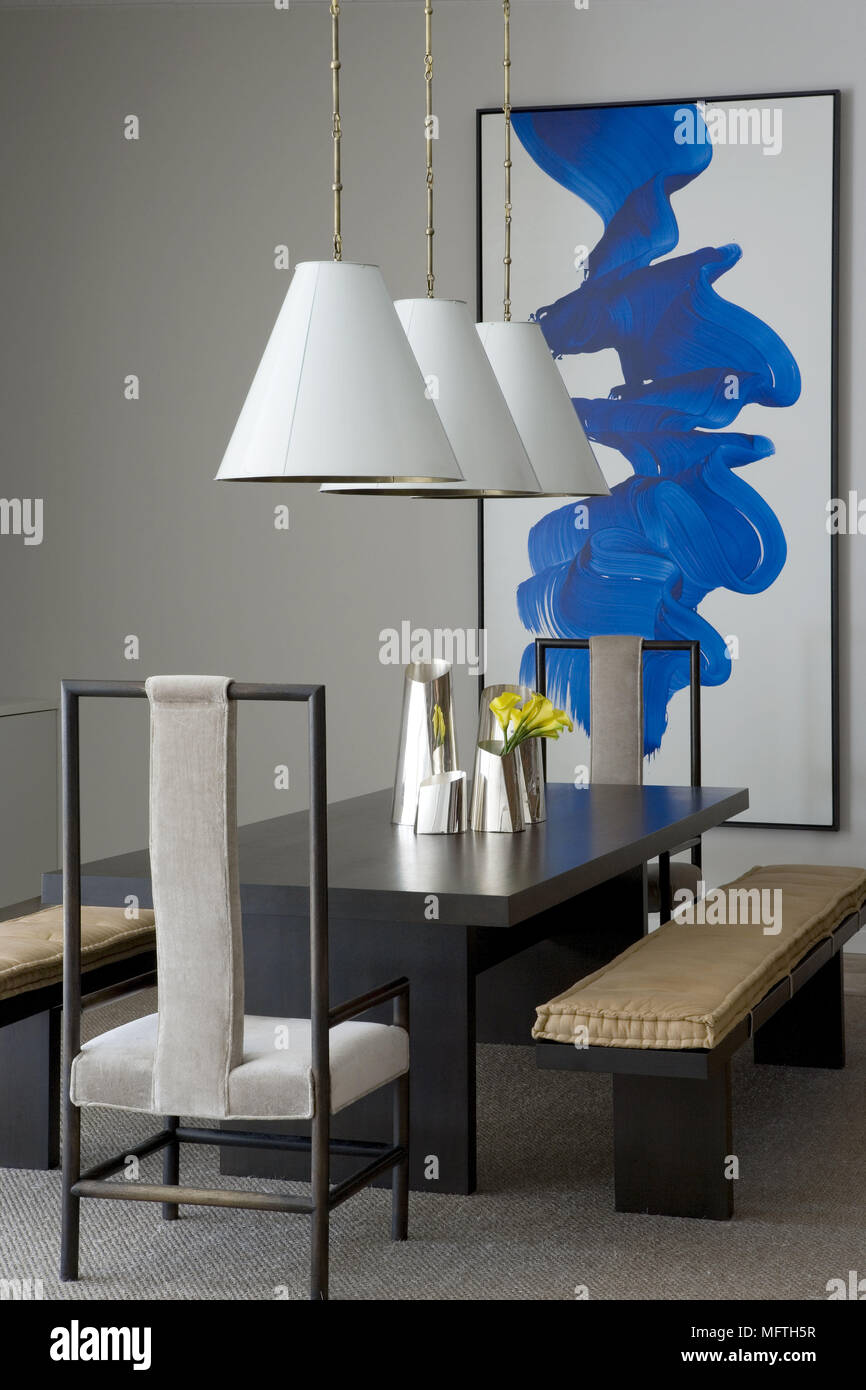 Ceiling lights above black wood table in modern dining room Stock Photo ...