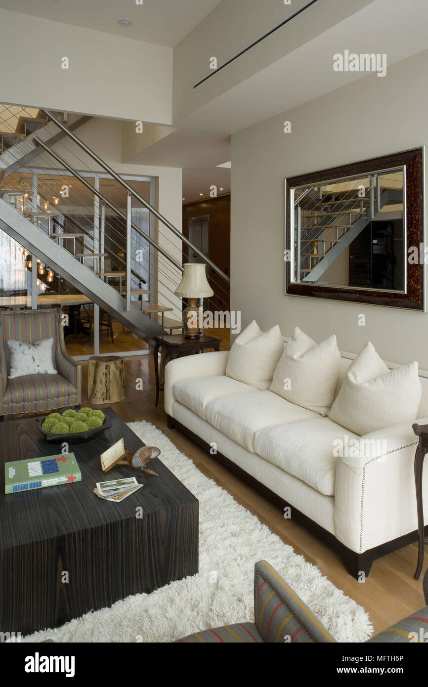 Coffee table in front of white sofa in modern open plan sitting room ...