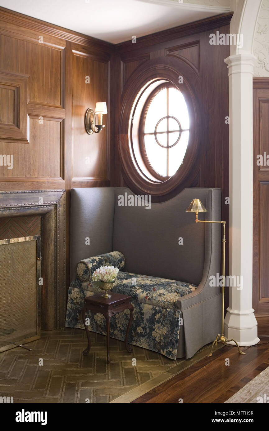 Inglenook seating next to fireplace in wood panelled room Stock Photo ...