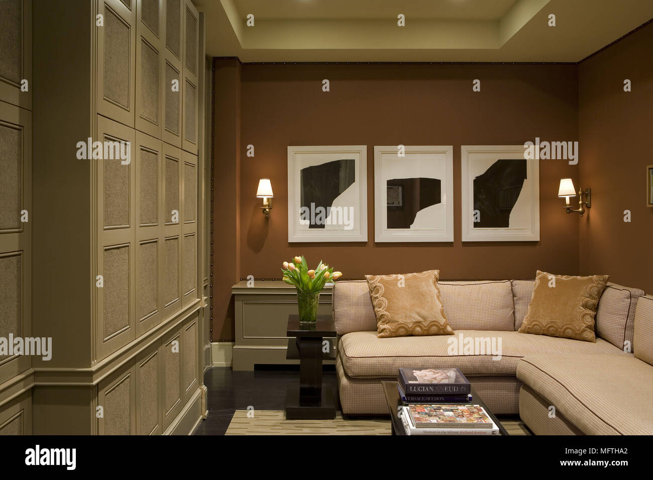 L shaped seating in traditional style sitting room with panelled walls ...