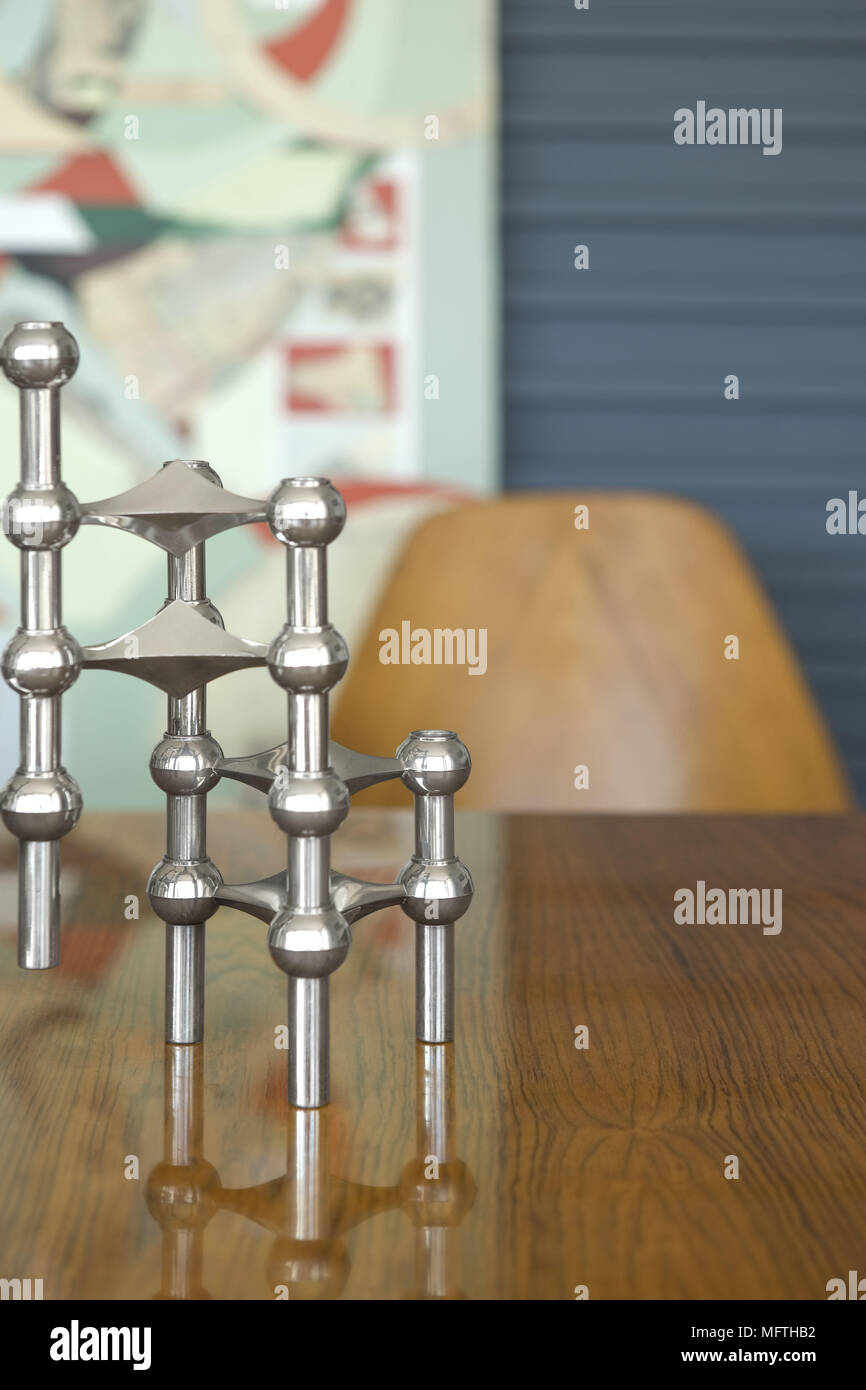 Modern metal sculpture on wooden dining table Stock Photo - Alamy