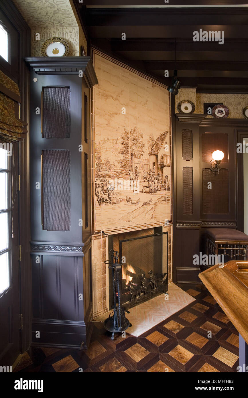 Mural above fireplace with lit fire in traditional style room Stock ...