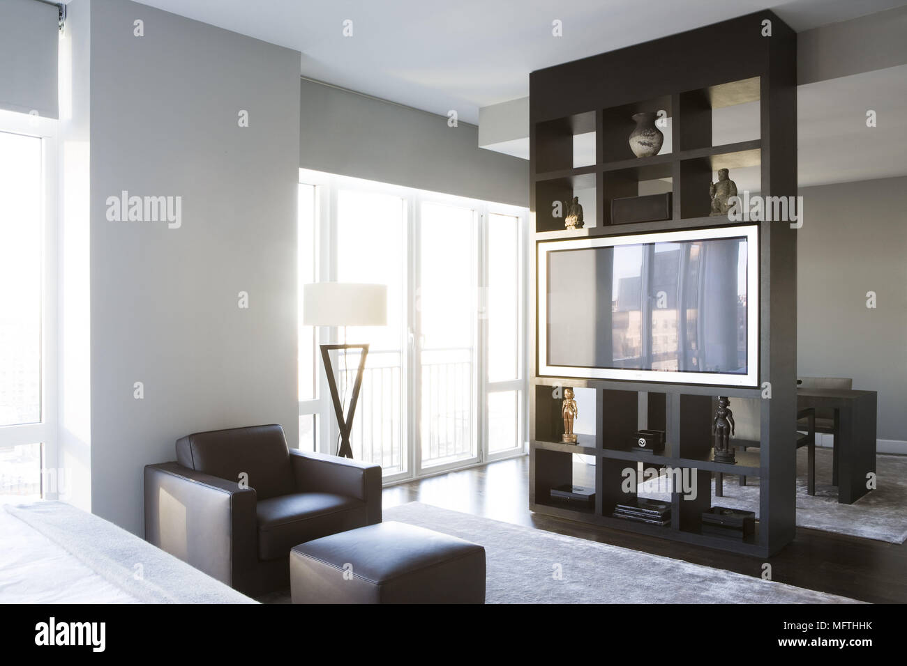 Widescreen television mounted in open display unit in modern sitting ...