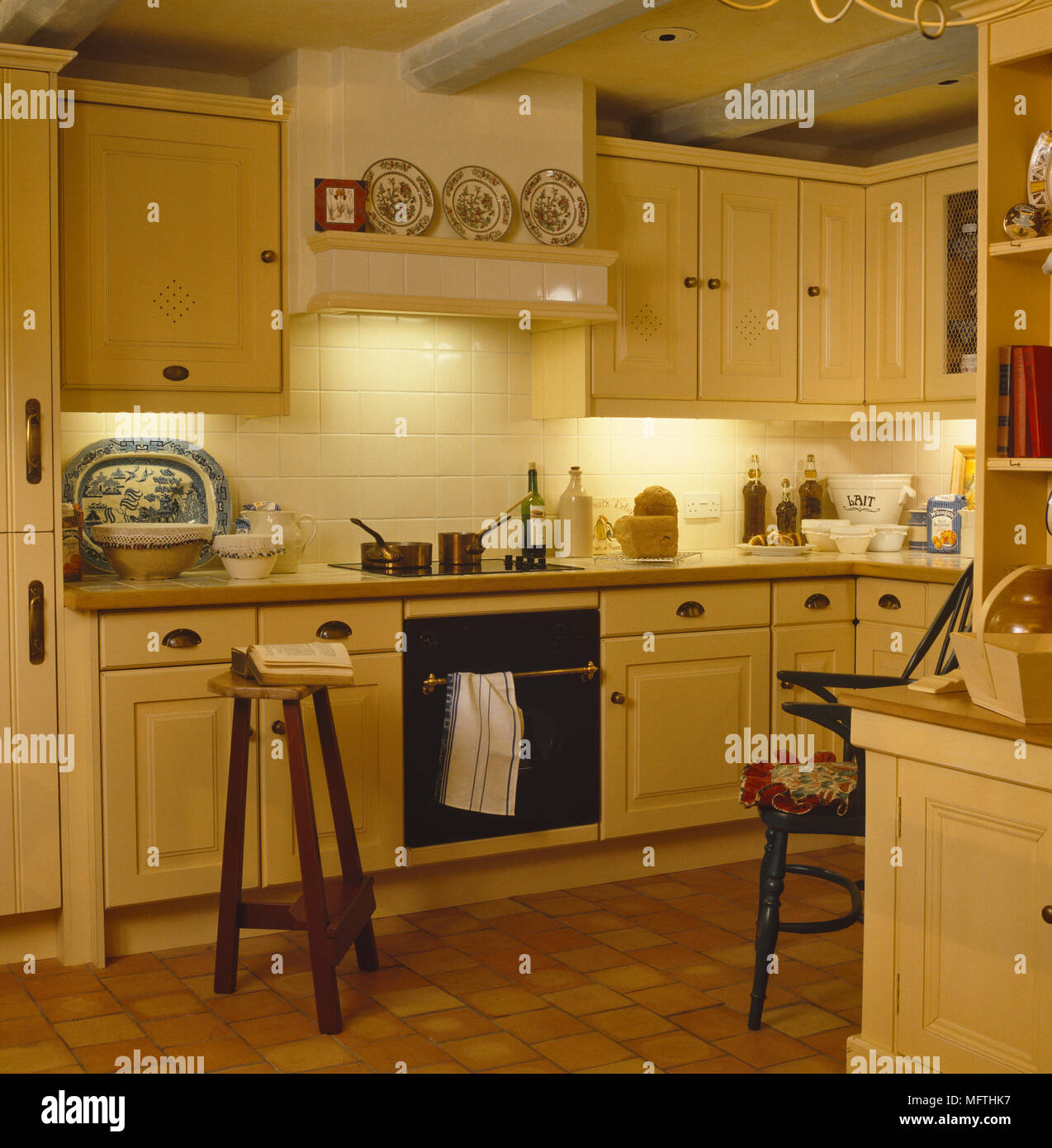 Country style kitchen with fitted wood units and tiled walls Stock ...