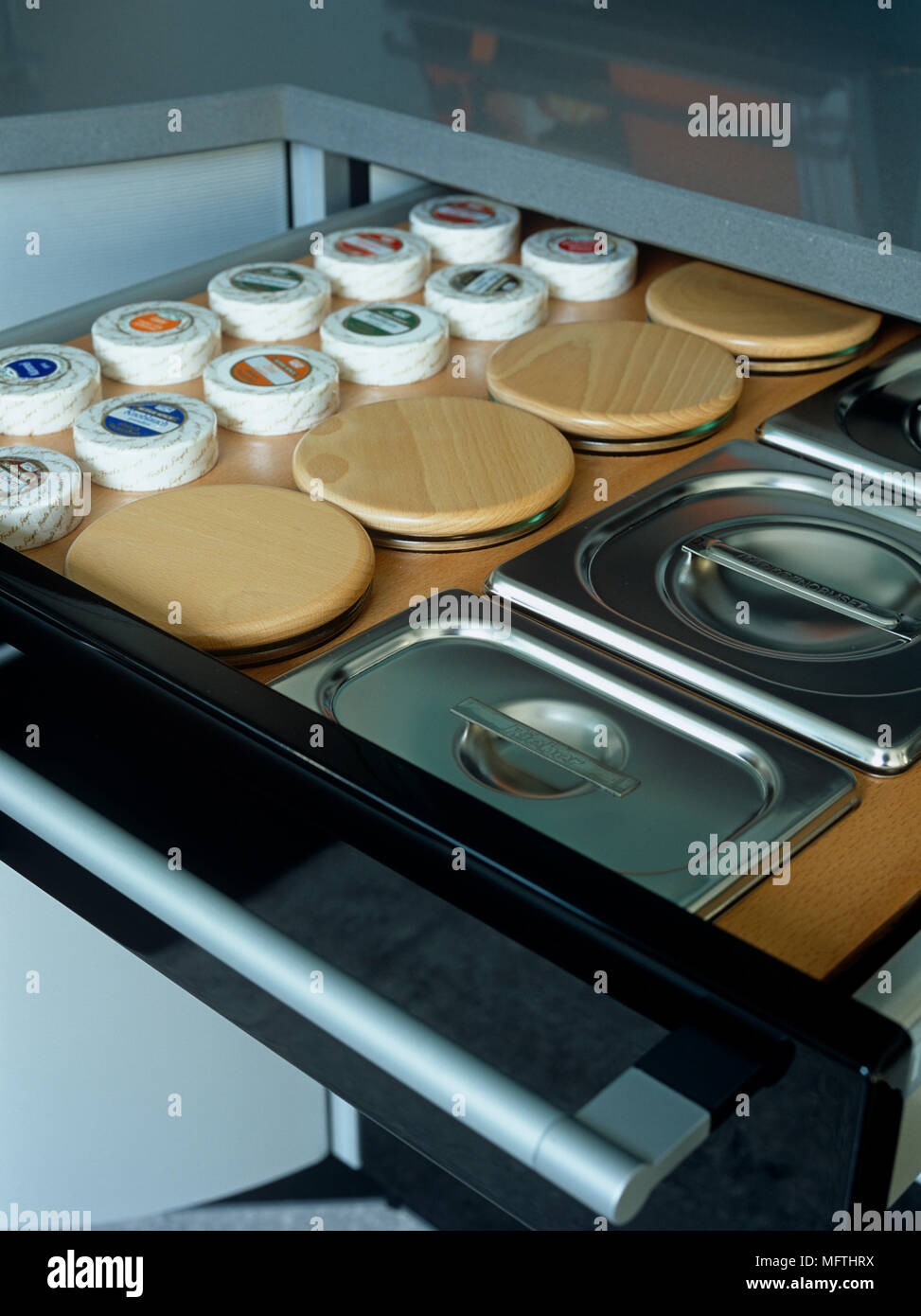 A detail of a modern kitchen, open drawer with storage compartments ...