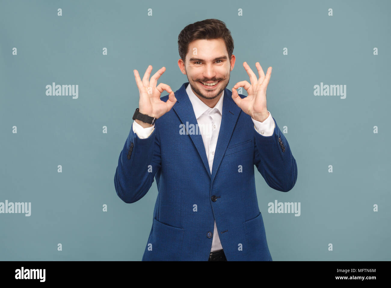 Handsome man with mustache showing ok sign at camera. Business people ...