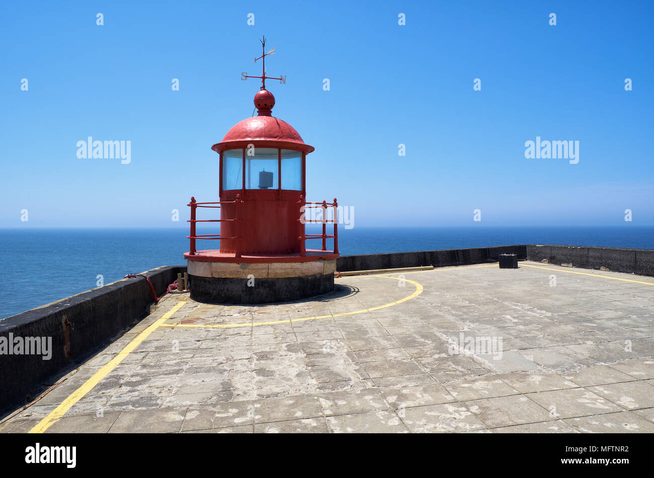 Red lighthouse lamp room on blue sky and sea background in Nazare ...