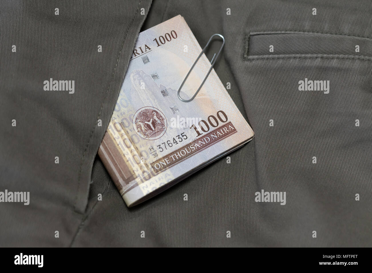 Nigerian Naira Bundles falling out of Pocket Stock Photo - Alamy