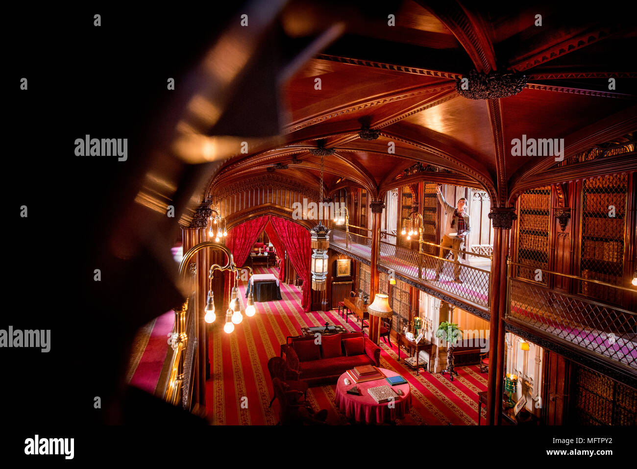 In the library at Arundel Castle a conservator checks the ornate ...