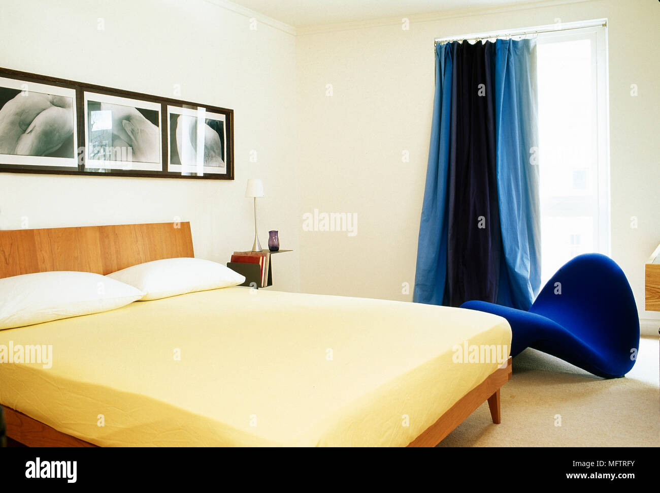Bedroom with blue curtains and blue shaped chair Stock Photo - Alamy