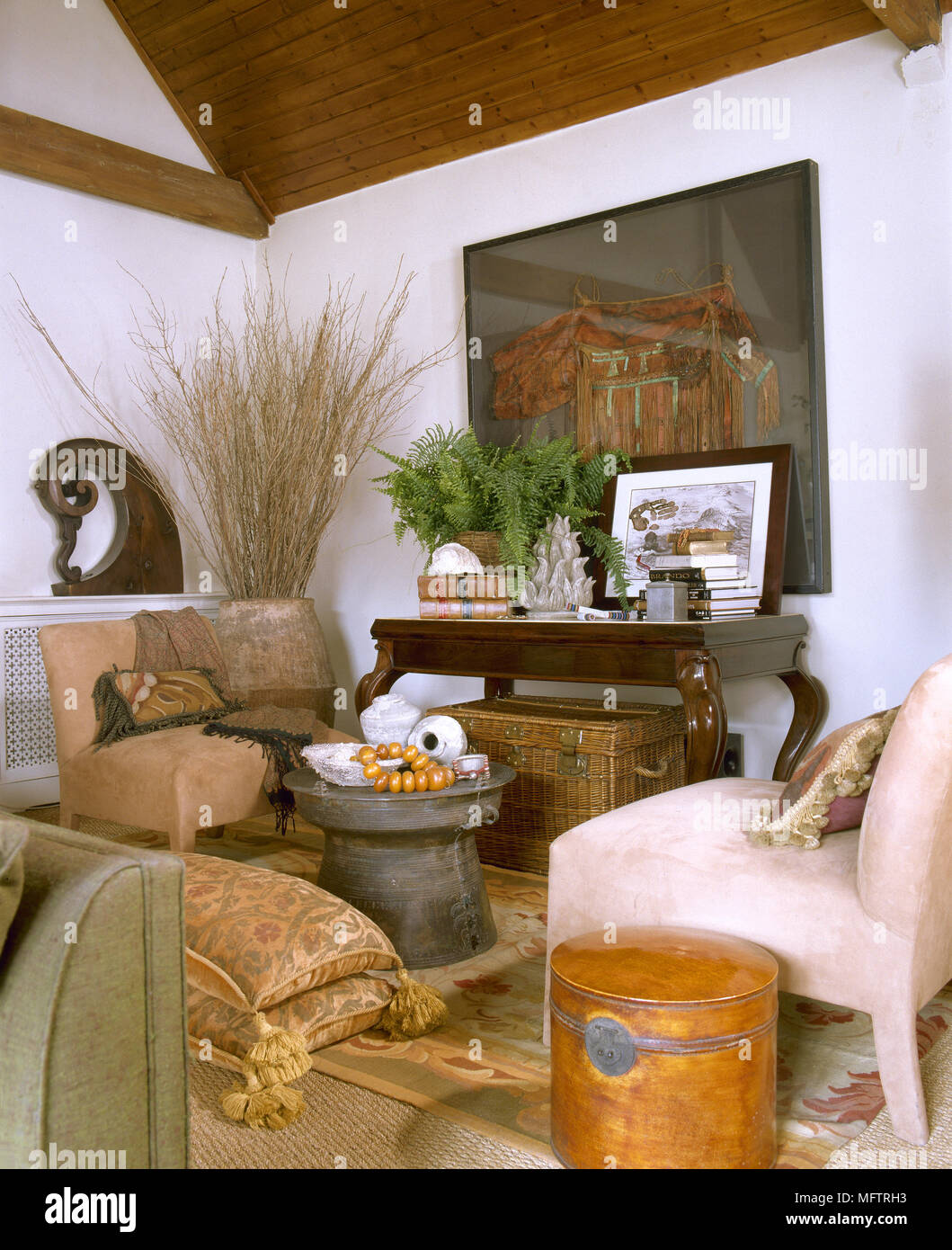 Exotic sitting room with a sloping, wood-panelled ceiling, upholstered ...