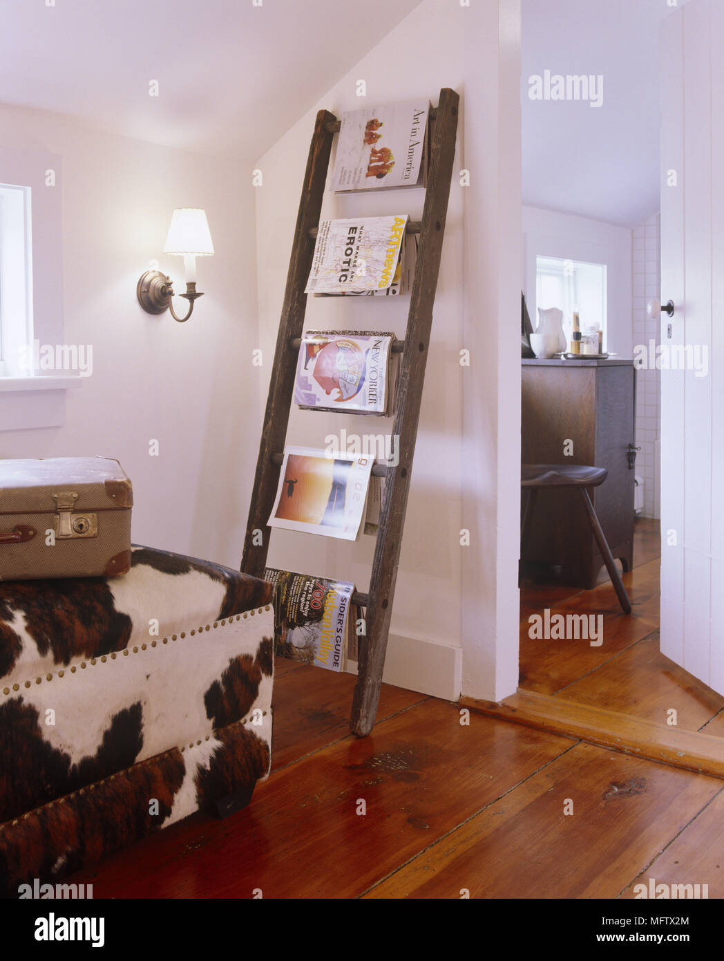 Magazines draped over rustic ladder propped against wall Stock Photo ...