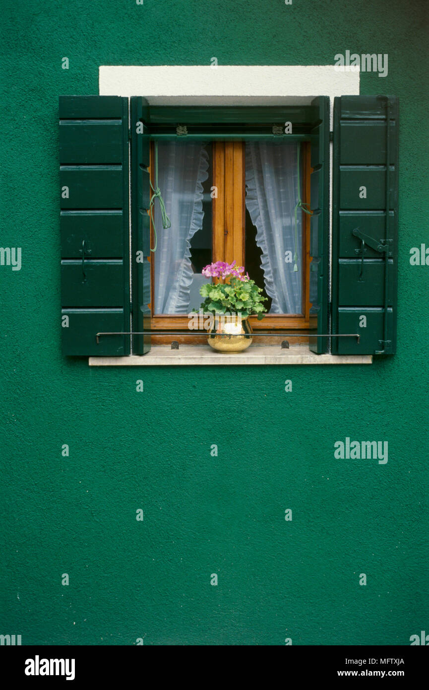 A detail of the exterior of a rustic wooden window with shutters, green ...