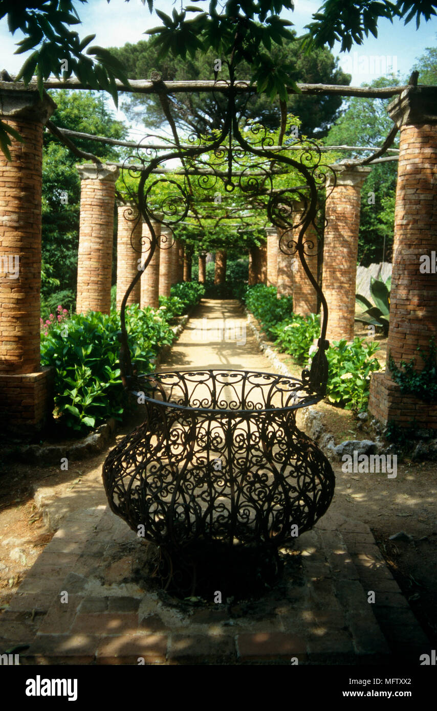 Gardens of Villa Cimbrone with a paved pathway through brick pillars ...