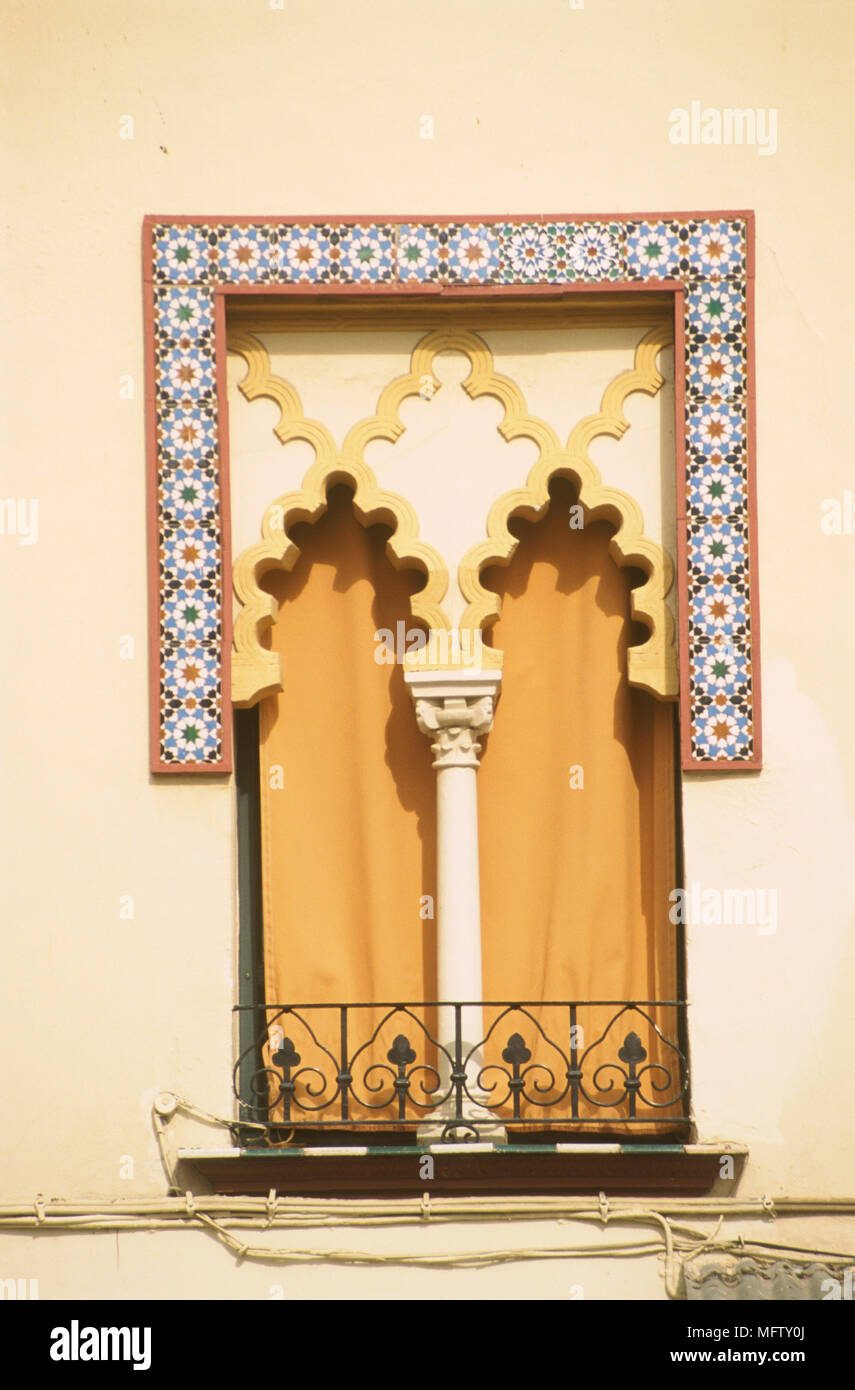 A detail of the exterior of a Moorish window with wrought iron railings ...