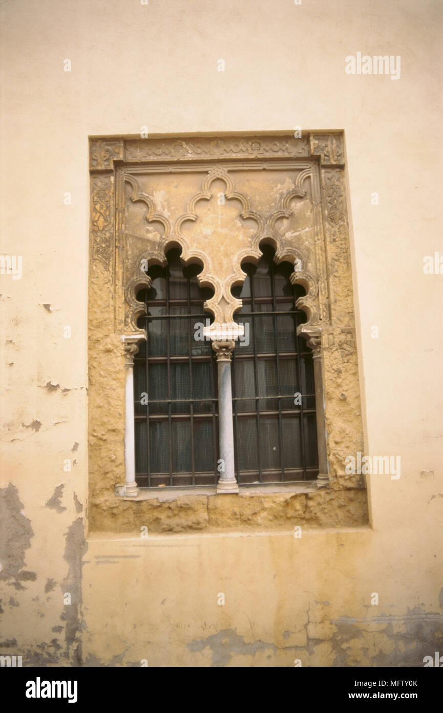 A detail of the exterior of a Moorish style window with wrought iron ...