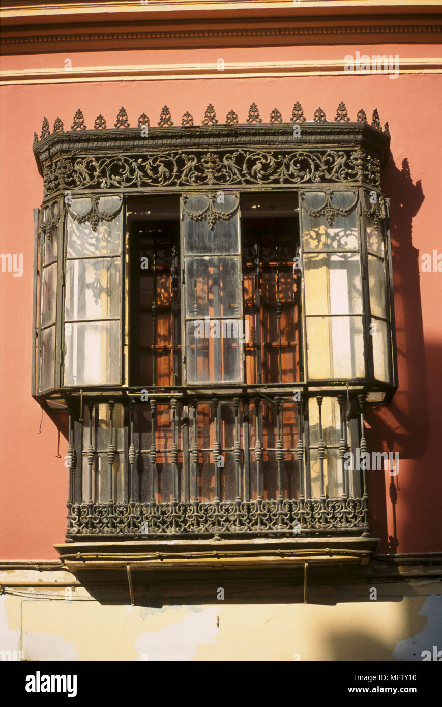 A detail of the exterior of a decorative window with wrought iron ...