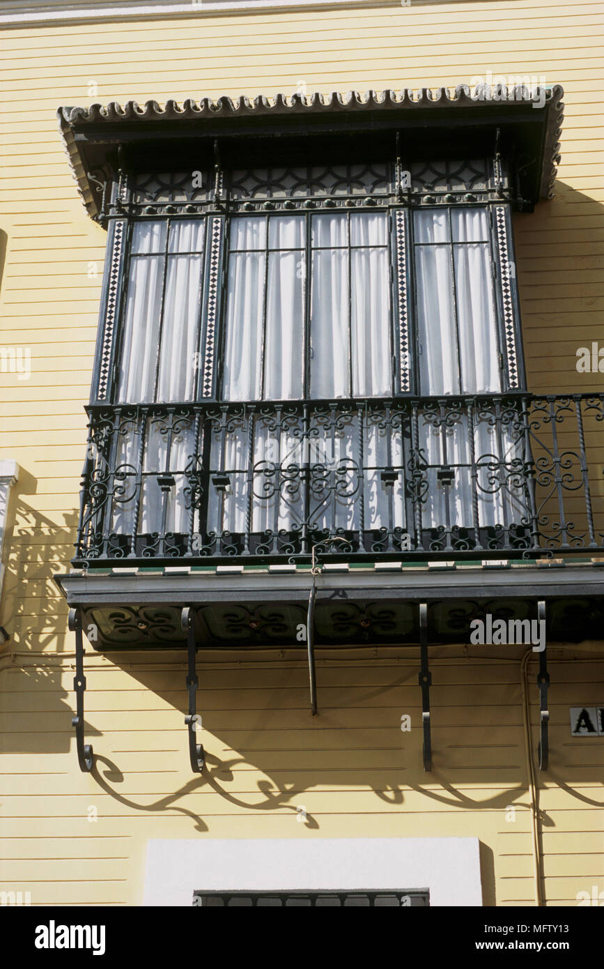 A detail of the exterior of a decorative window with wrought iron ...