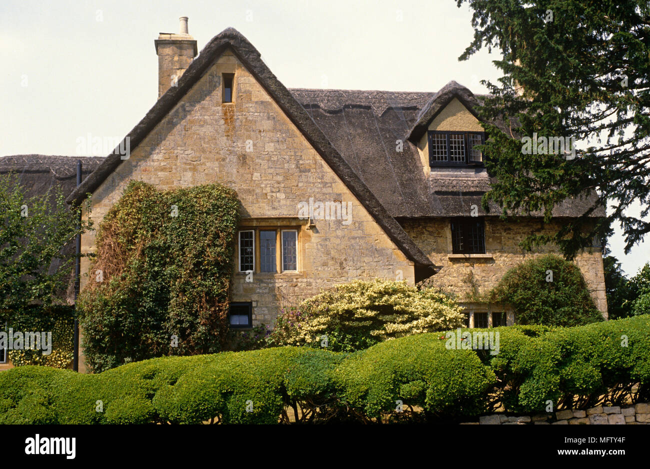 Exterior of Cotswold stone thatched cottage Stock Photo - Alamy