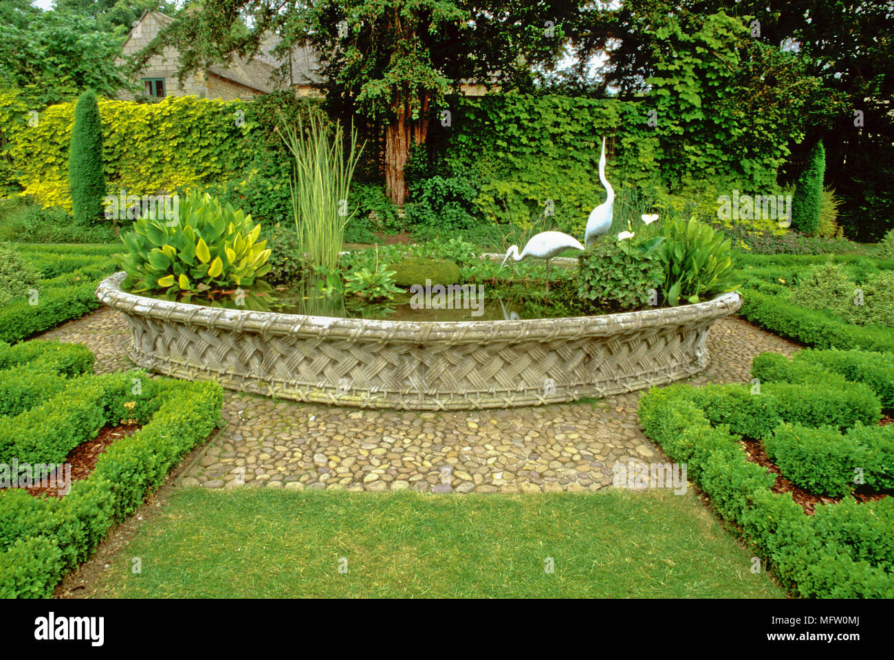 Circular stone pond with plantings of Buxus and Pontedaria Stock Photo ...