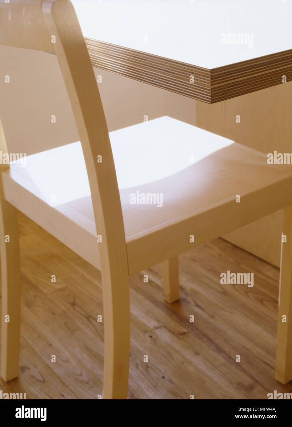 A detail of a modern wooden chair under desk wooden floor Stock Photo ...