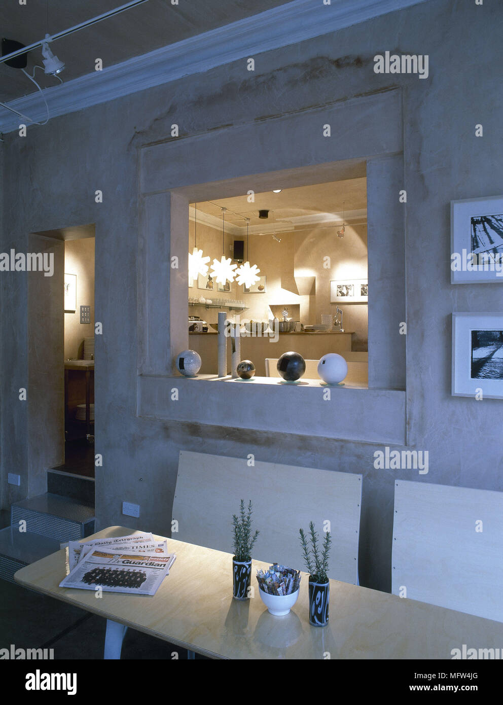 Dining room with view through hatch to illuminated area Stock Photo - Alamy