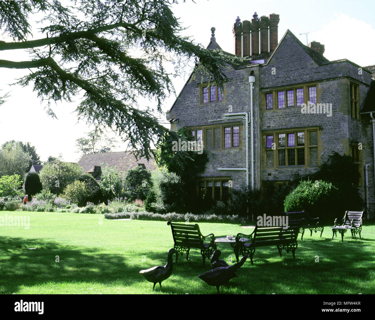Exterior view of a shady bench seating area outside Le Manoir Quartre ...