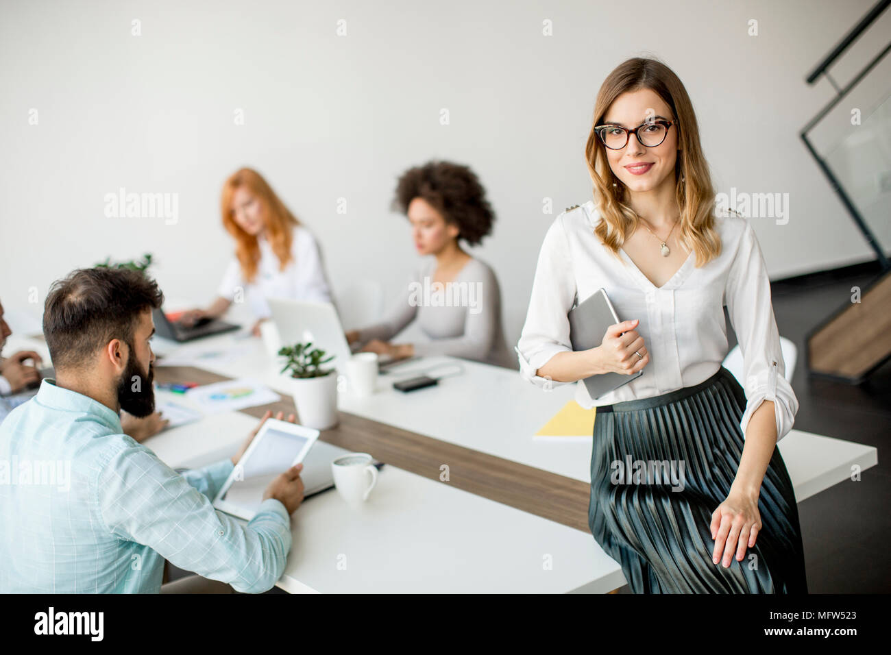 Young attractive female manager working on digital tablet while ...