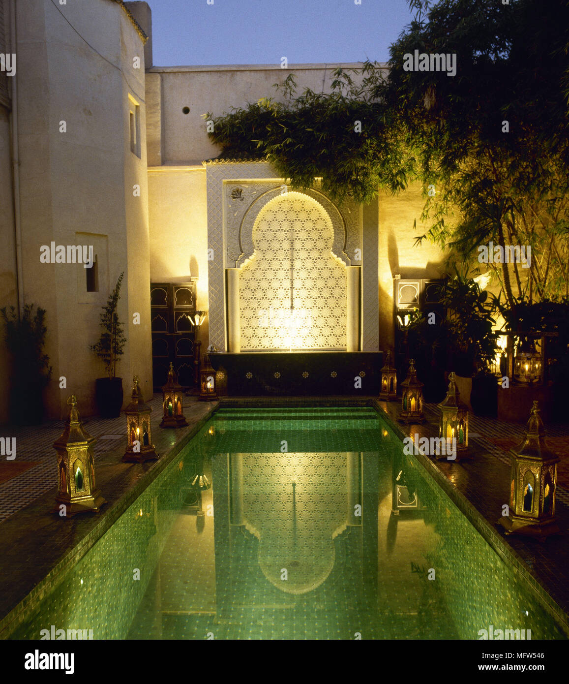 Outdoor swimming pool in moorish style courtyard lit at night Stock ...