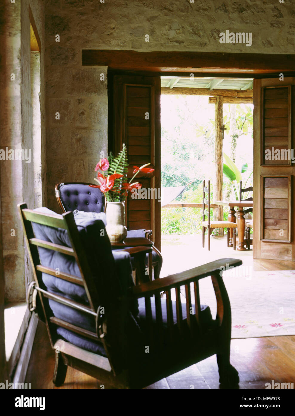 Rustic sitting room with stone walls wood floor wooden armchairs and an ...