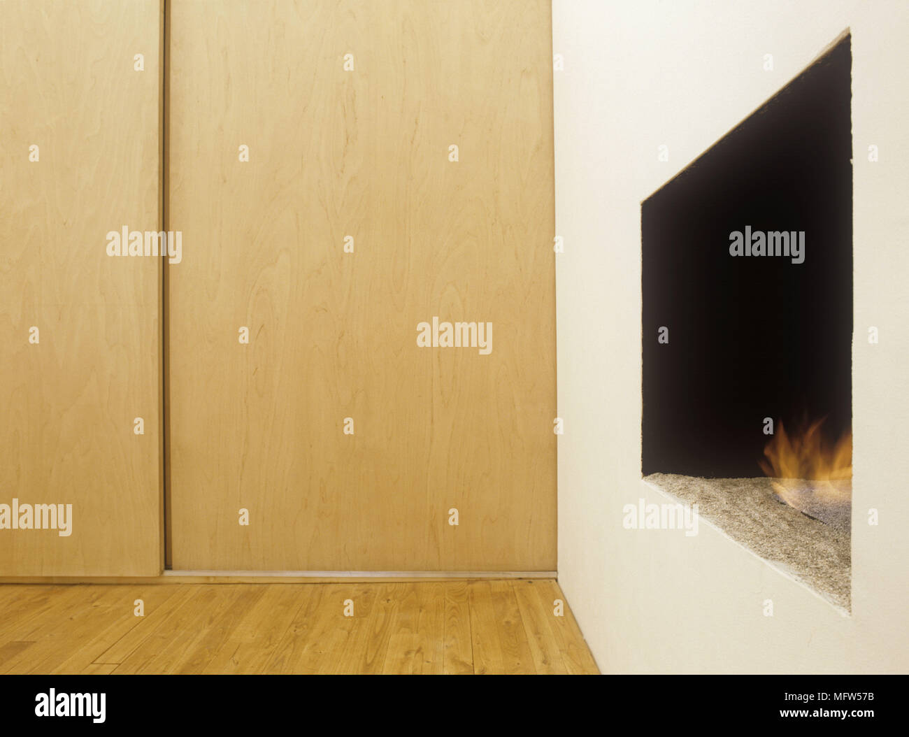 Simple fireplace with lit fire Stock Photo - Alamy