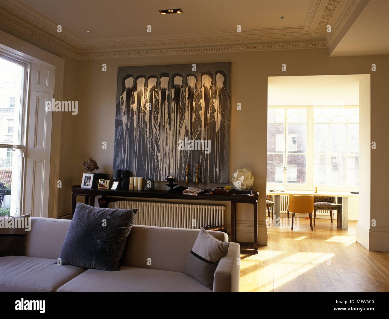 Upholstered sofa in front of table Stock Photo - Alamy