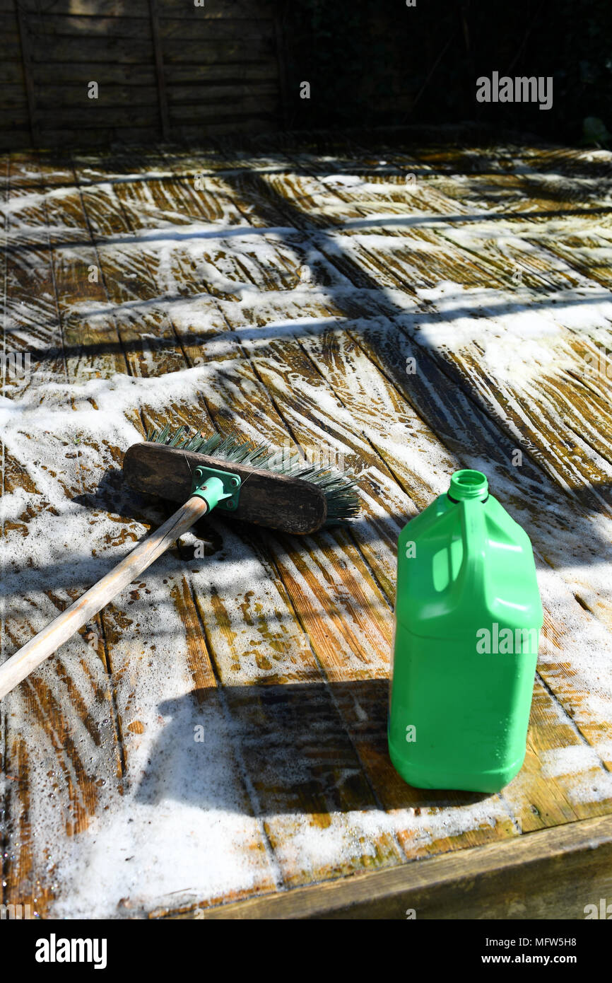 Green and dirty algae covered garden decking in the process of being ...