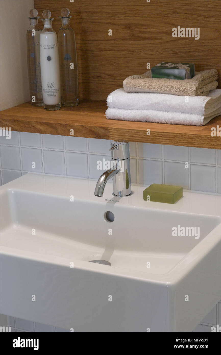 Bar of Soap on a modern wash basin below a wooden shelf with folded ...