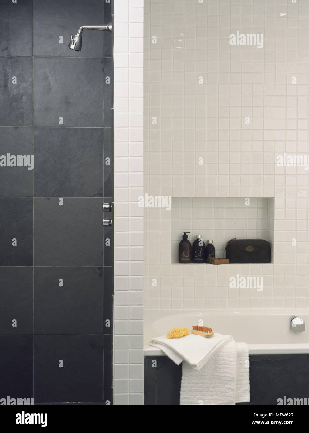 Details of a modern bathroom with a shower with dark tiles next to a ...