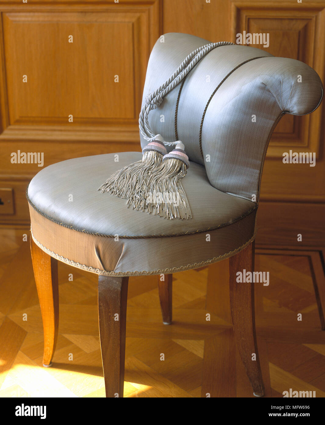 Traditionally upholstered chair with wooden legs and tassels Stock ...
