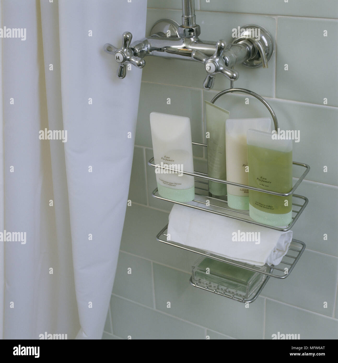 A detail of a modern bathroom showing a tiled shower with chrome tap ...