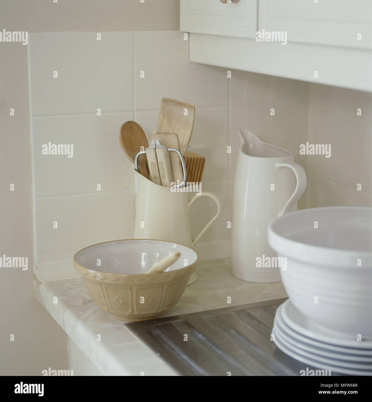 A detail of a modern neutral country kitchen utensils in a jug mixing ...