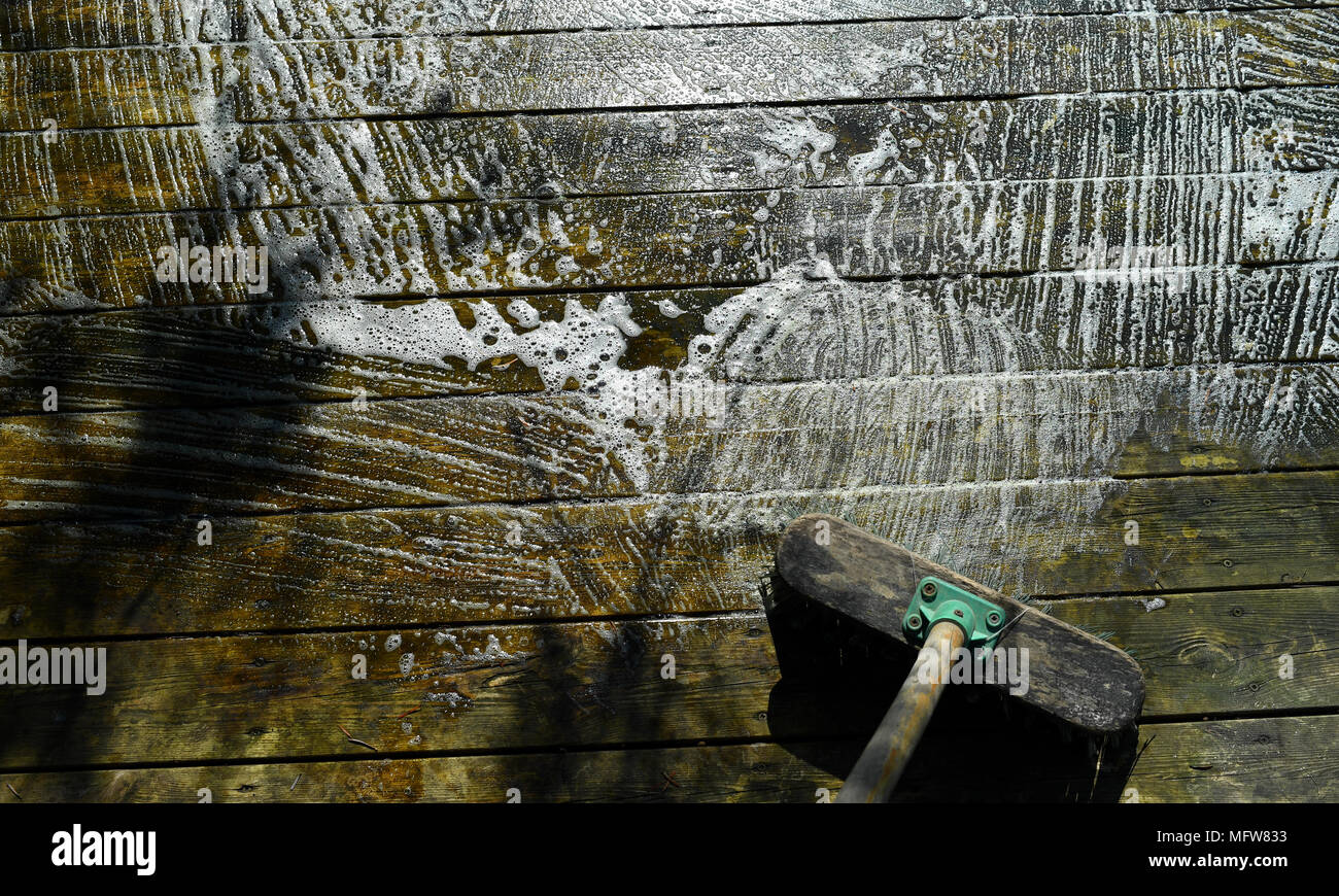 Green and dirty algae covered garden decking in the process of being ...