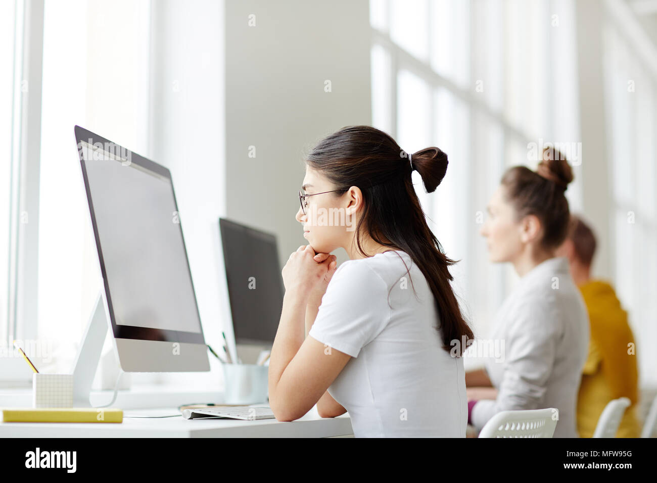 Group of students sitting at computer class and working on computer ...