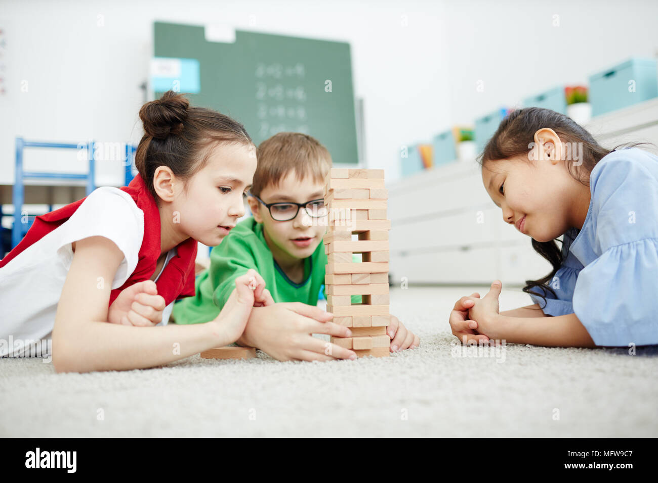 Multiethnic group of elementary school children lying on the floor and ...