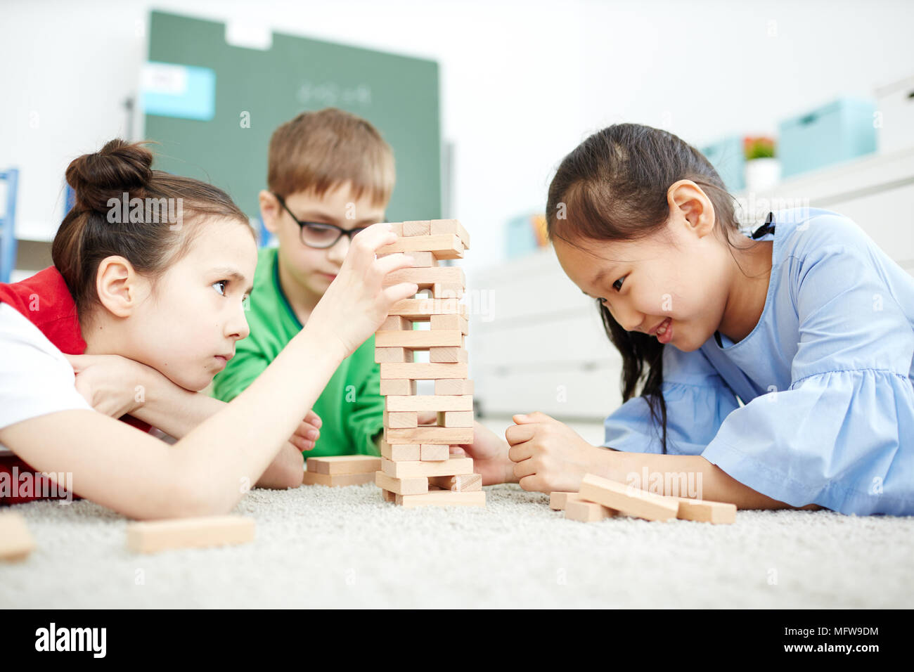 Multiethnic group of primary school children sitting on the floor in ...