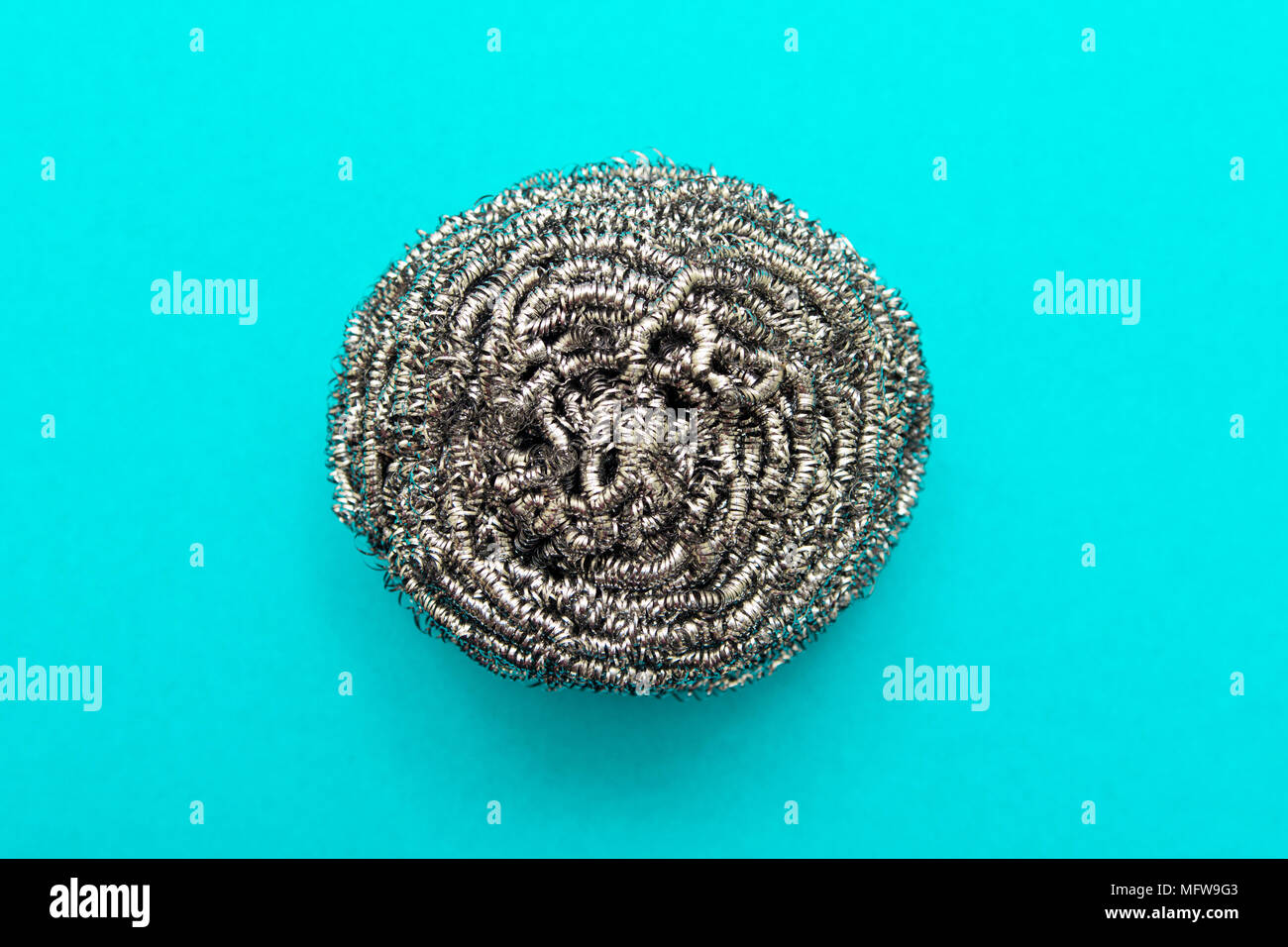 Metal sponge for washing dishes closeup on a colored background with ...