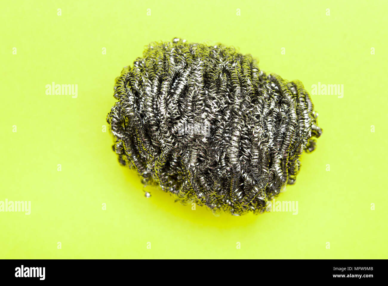 Metal sponge for washing dishes closeup on a colored background with ...
