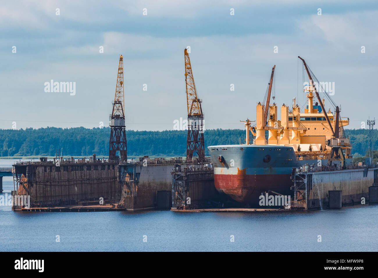 Yellow bulk carrier standing at the old shipyard in the dock Stock ...