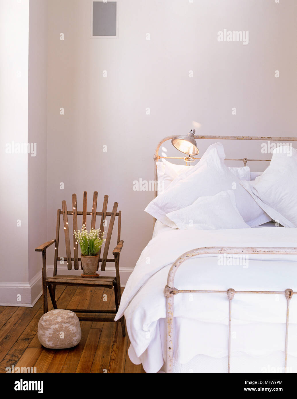 Bedroom with iron frame bed and white linen Stock Photo - Alamy