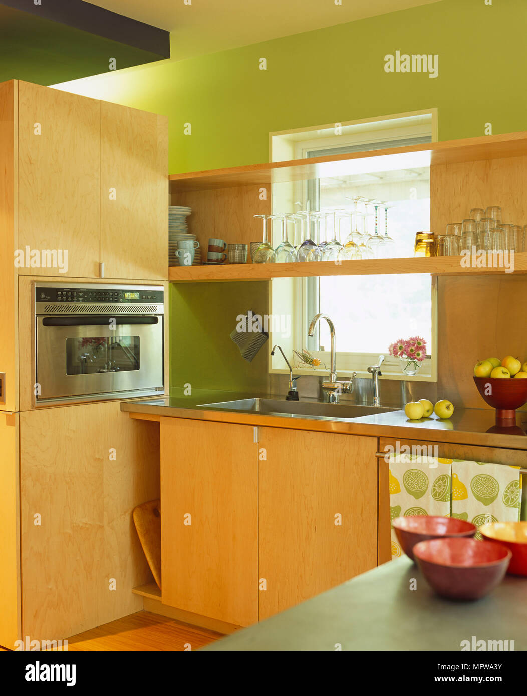 Contemporary kitchen with wood fitted units and shelf above sink Stock ...
