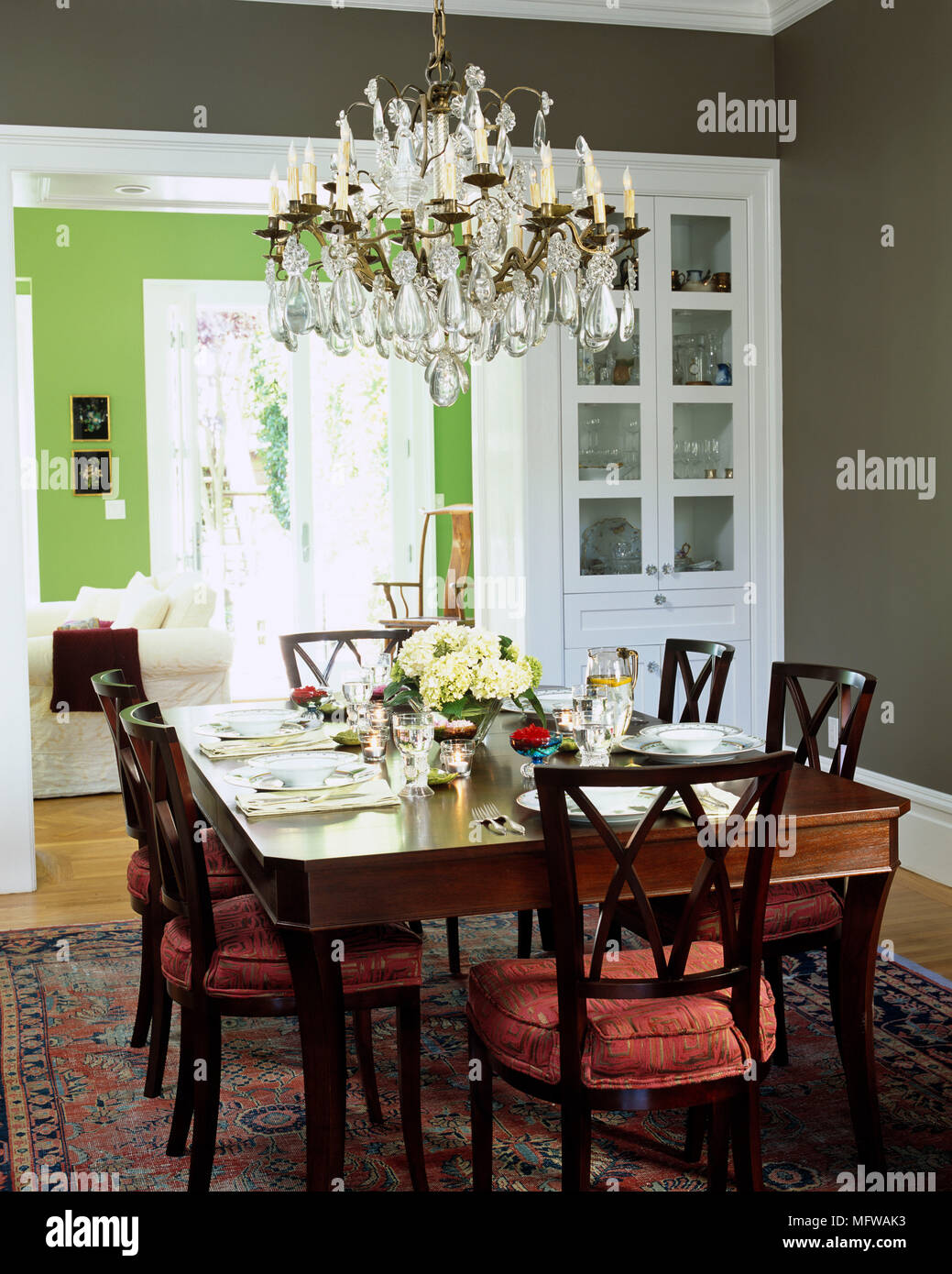 Glass chandelier above table laid for dinner in traditional style ...